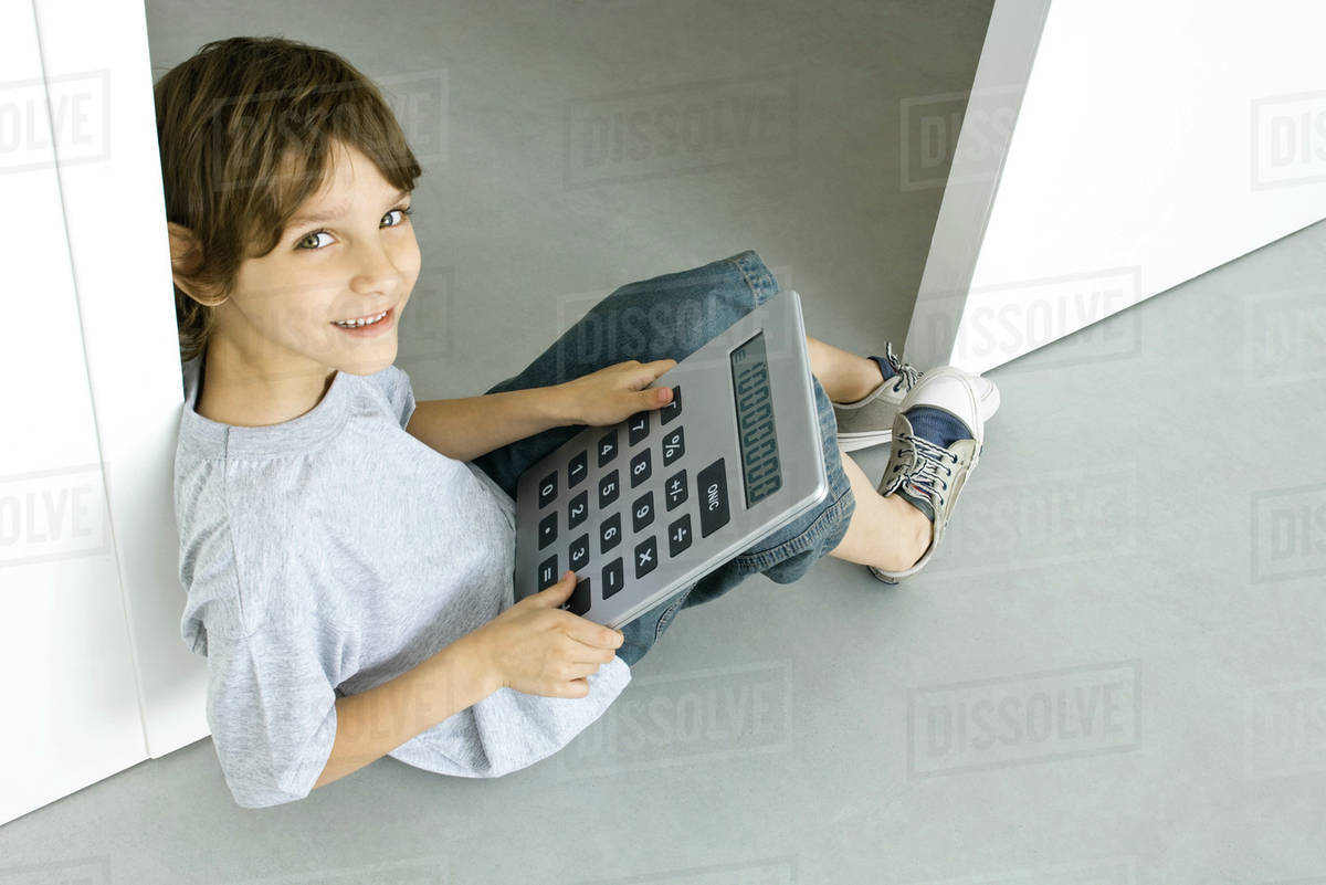 Boy using oversized calculator - Royalty-free Stock Photo | Dissolve