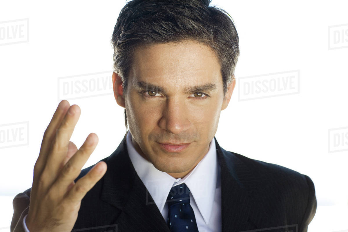 Confident businessman making hand gesture, looking at the camera ...