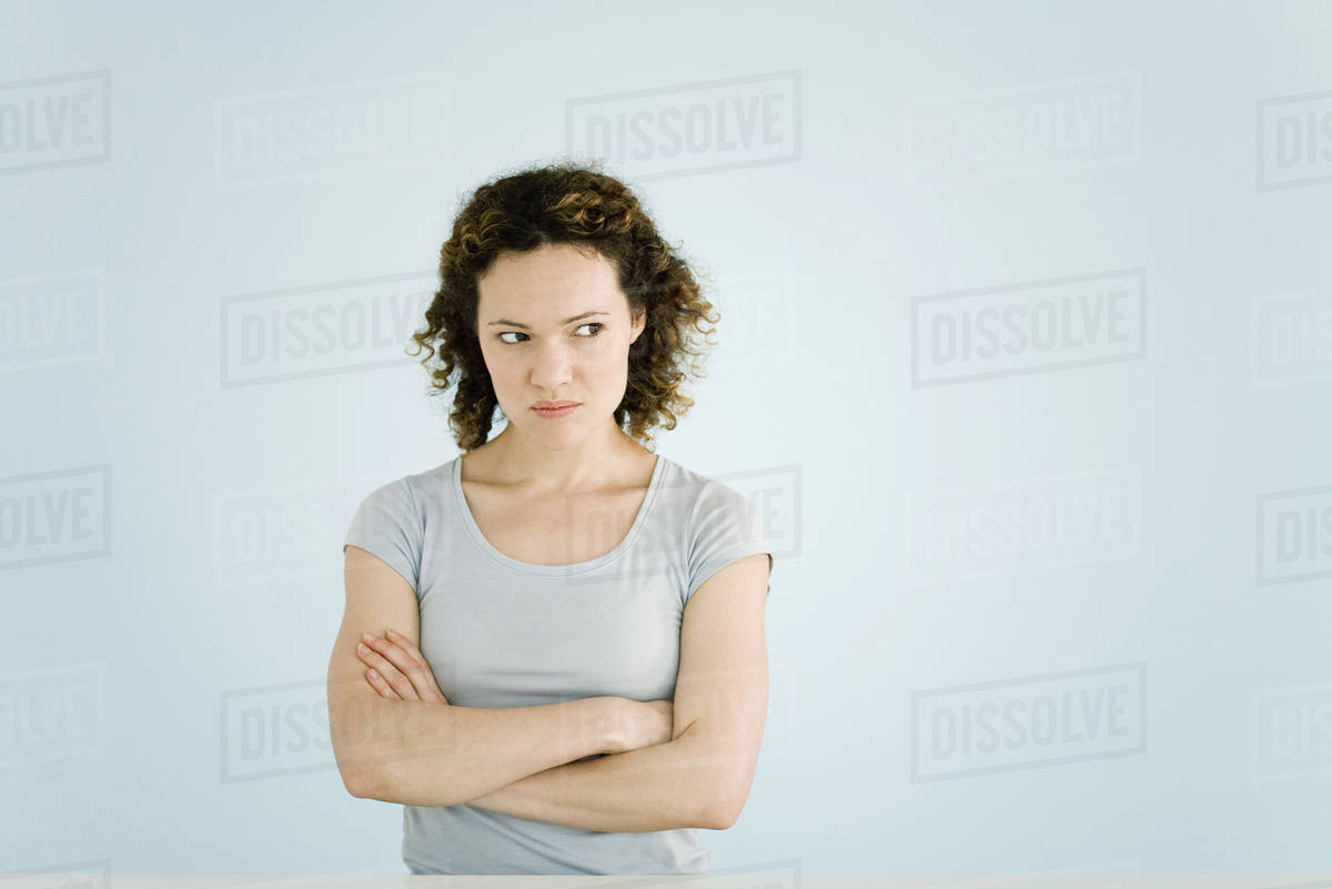 Woman sulking, arms folded, portrait - Stock Photo - Dissolve