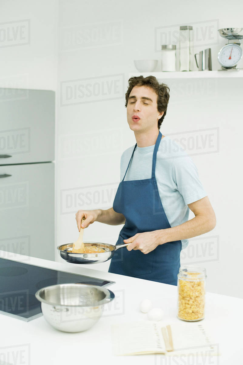 Man standing at stove, cooking, eyes closed, whistling - Royalty-free ...