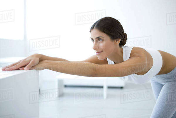 Woman stretching, bending over, arms outstretched - Royalty-free Stock ...