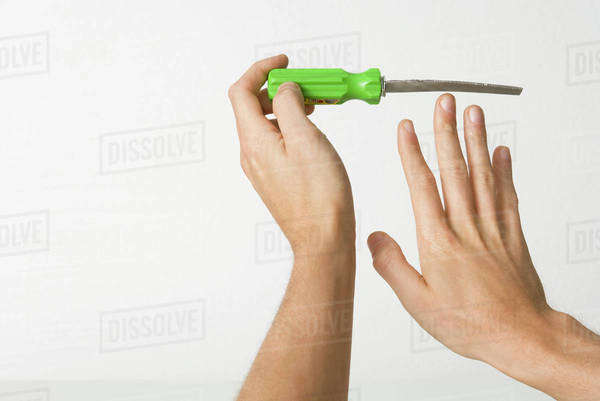 Hands holding sharp file - Stock Photo - Dissolve