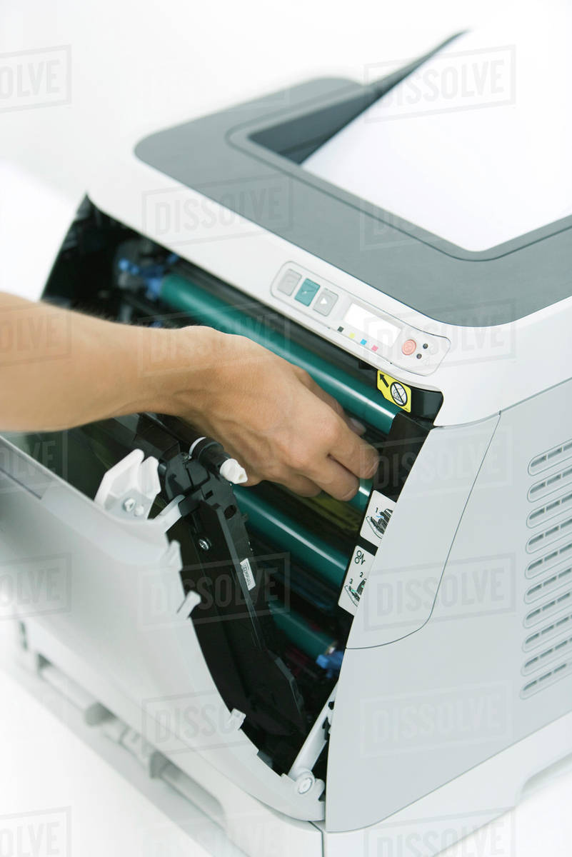 Person fixing paper jam in printer, cropped view - Stock Photo - Dissolve