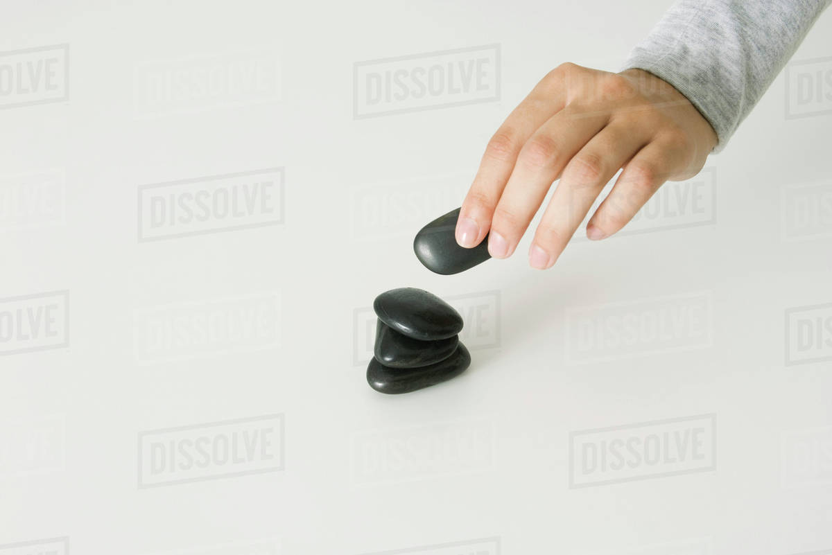 Hand stacking smooth black stones, cropped view - Royalty-free Stock ...