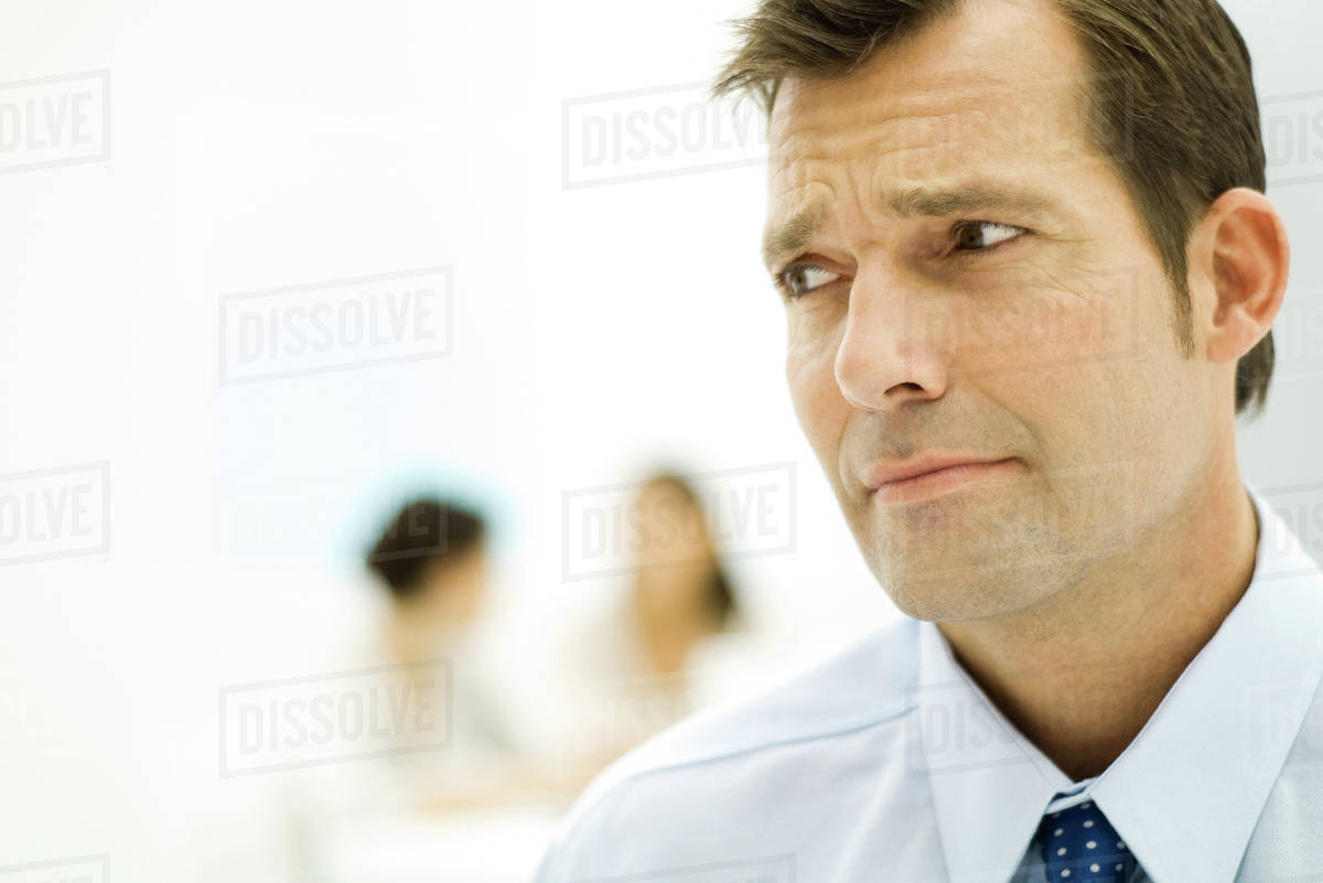 Businessman furrowing brow, looking out of frame, close-up - Royalty ...