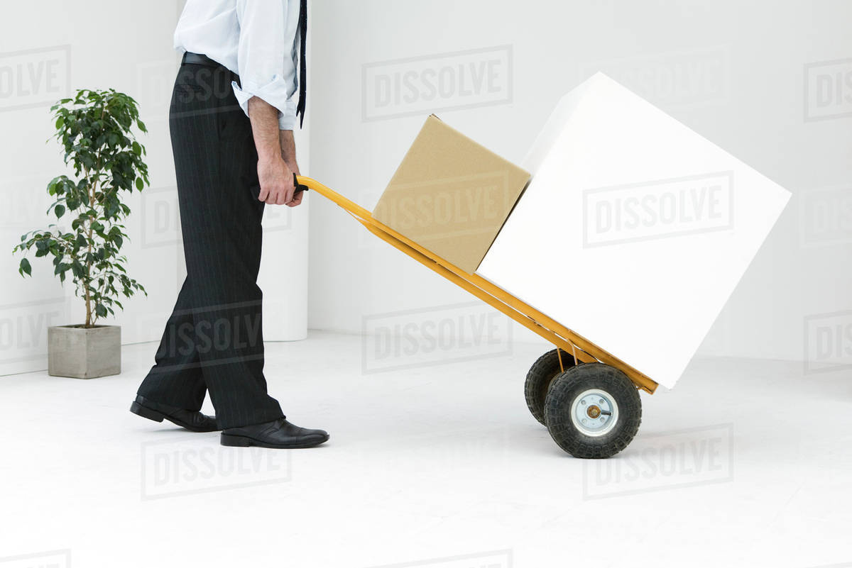 Businessman moving boxes with hand truck - Royalty-free Stock Photo ...