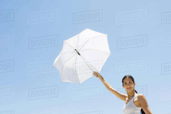 Woman holding up parasol, smiling at camera - Royalty-free Stock Photo ...