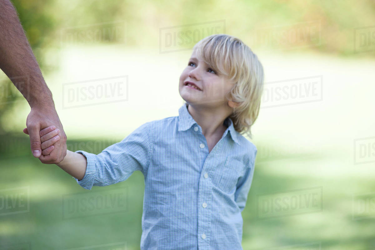 Little boy holding father's hand - Stock Photo - Dissolve