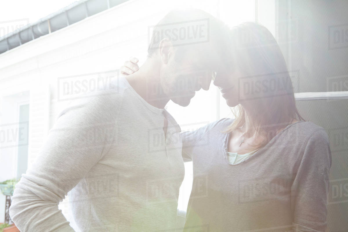 Couple touching heads, smiling - Royalty-free Stock Photo | Dissolve
