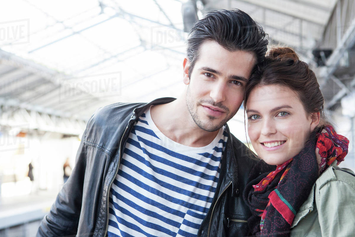 Young couple together on train platform, portrait - Stock Photo - Dissolve