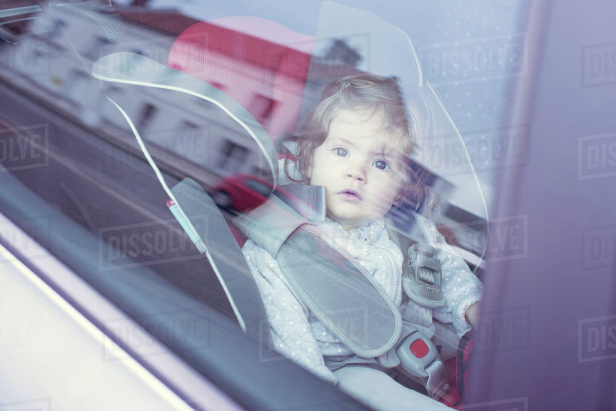 Baby girl sitting in car seat, gazing through car window - Stock Photo ...