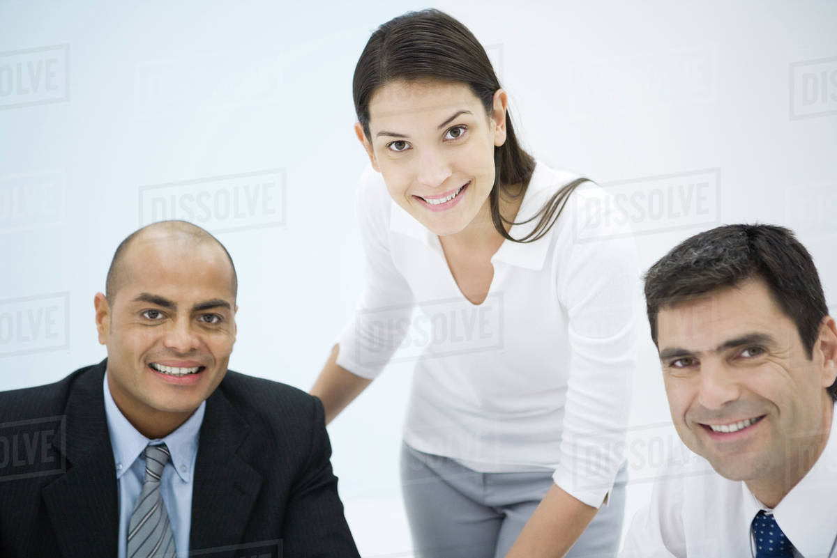 Business associates smiling at camera, portrait - Stock Photo - Dissolve