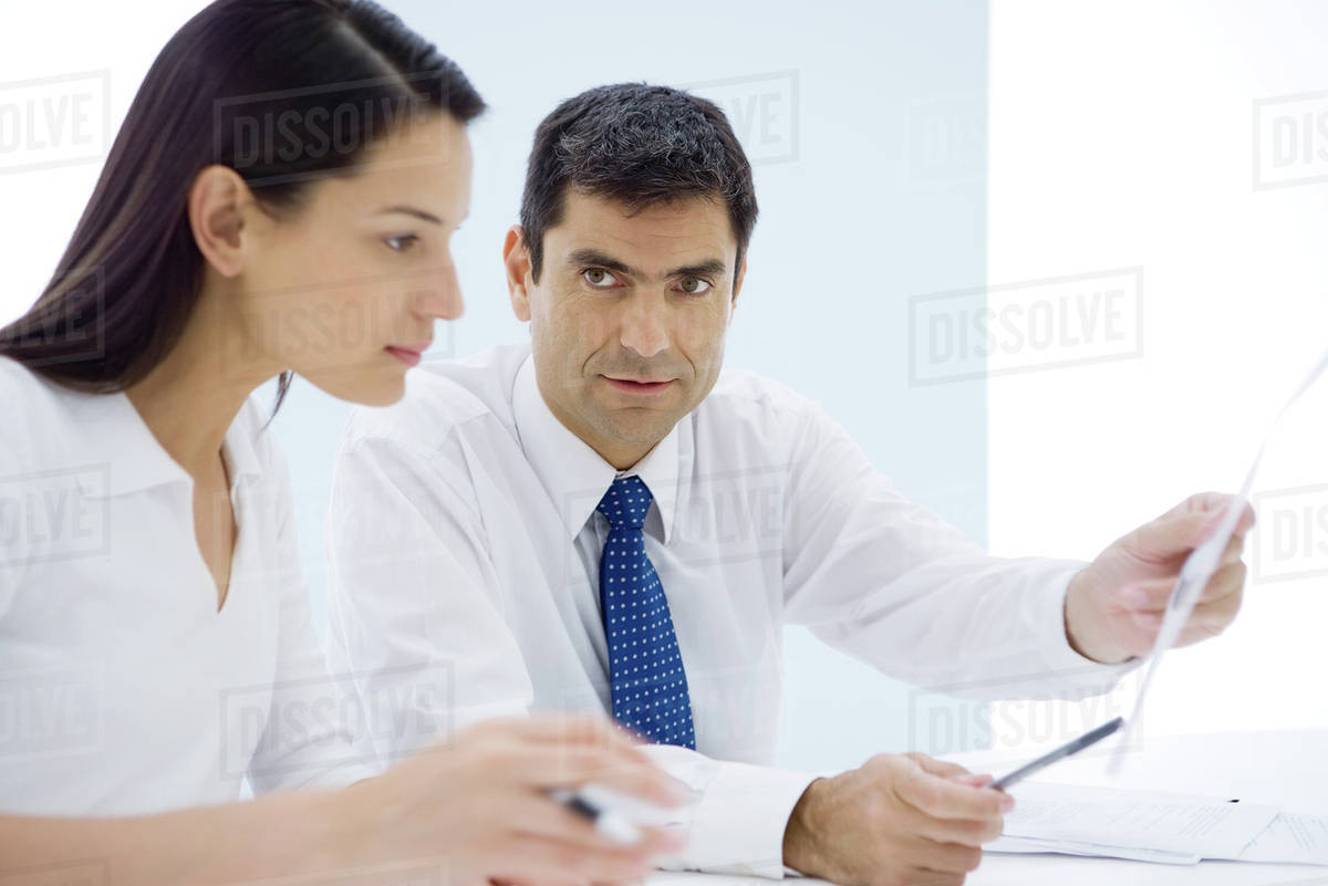 Businessman showing document to female associate - Royalty-free Stock ...