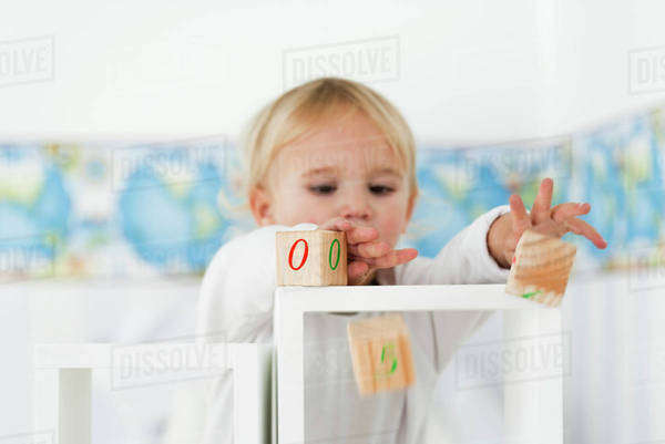 Baby pushing blocks off shelves - Royalty-free Stock Photo | Dissolve