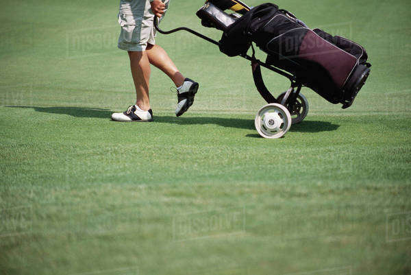Golfer pulling caddy - Royalty-free Stock Photo | Dissolve