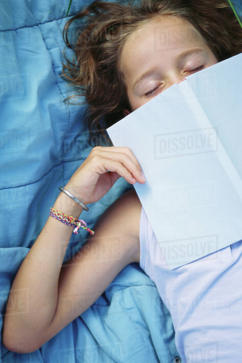 Girl sleeping with book over face - Royalty-free Stock Photo | Dissolve