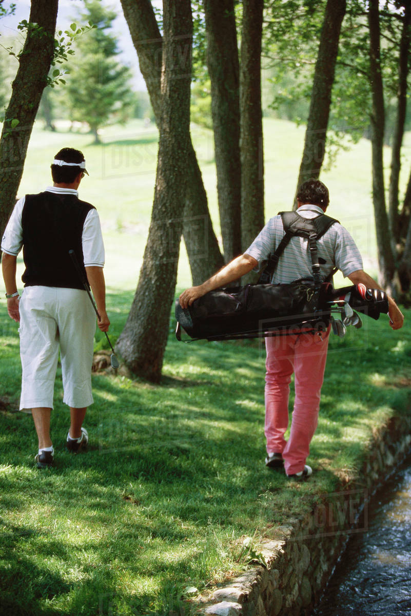 Golfers looking for ball under trees, rear view - Royalty-free Stock ...
