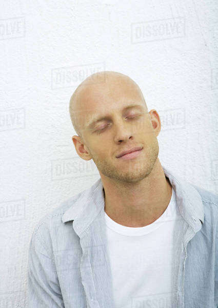 Young man with eyes closed, portrait - Royalty-free Stock Photo | Dissolve