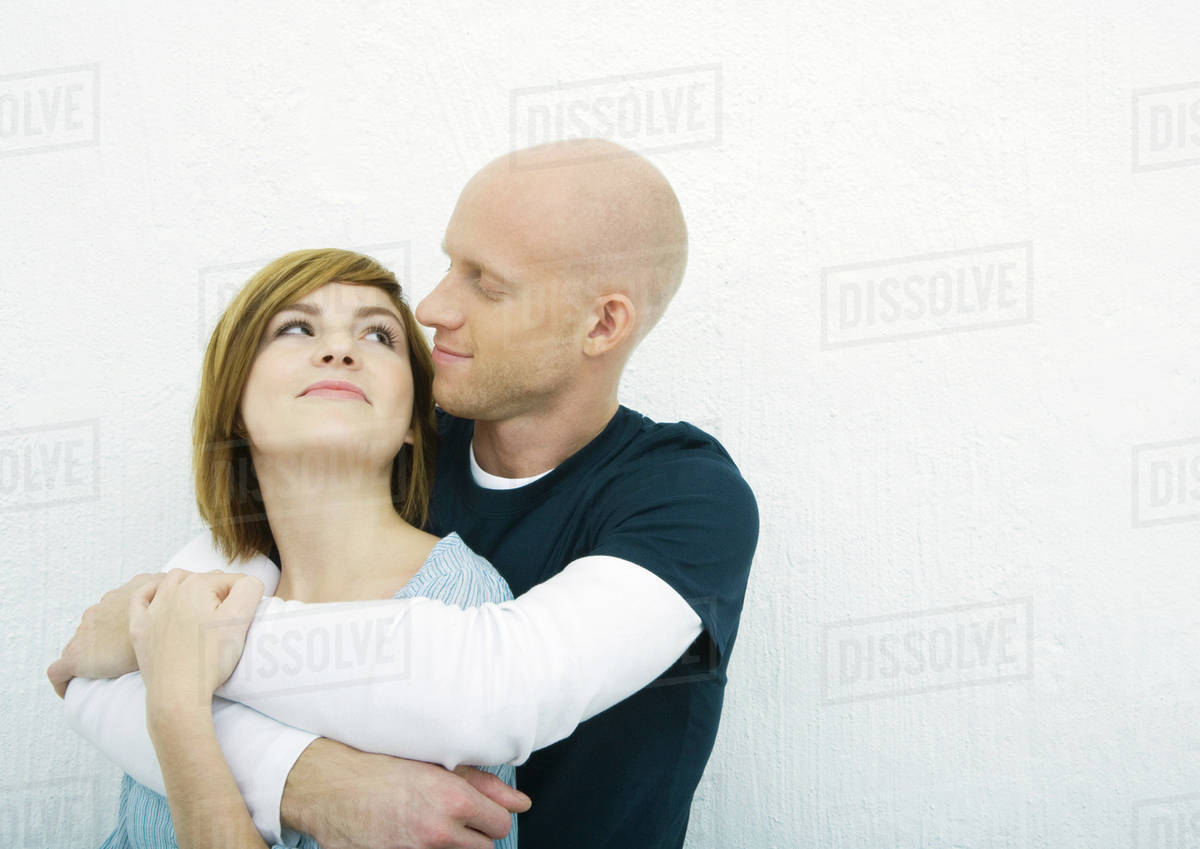 Young Couple Man Holding Woman From Behind Looking At Each Other