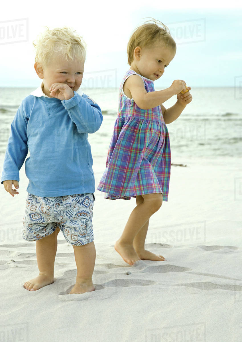 Two toddlers standing on beach - Royalty-free Stock Photo | Dissolve