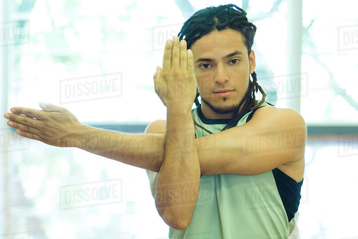 Man doing arm stretches - Stock Photo - Dissolve