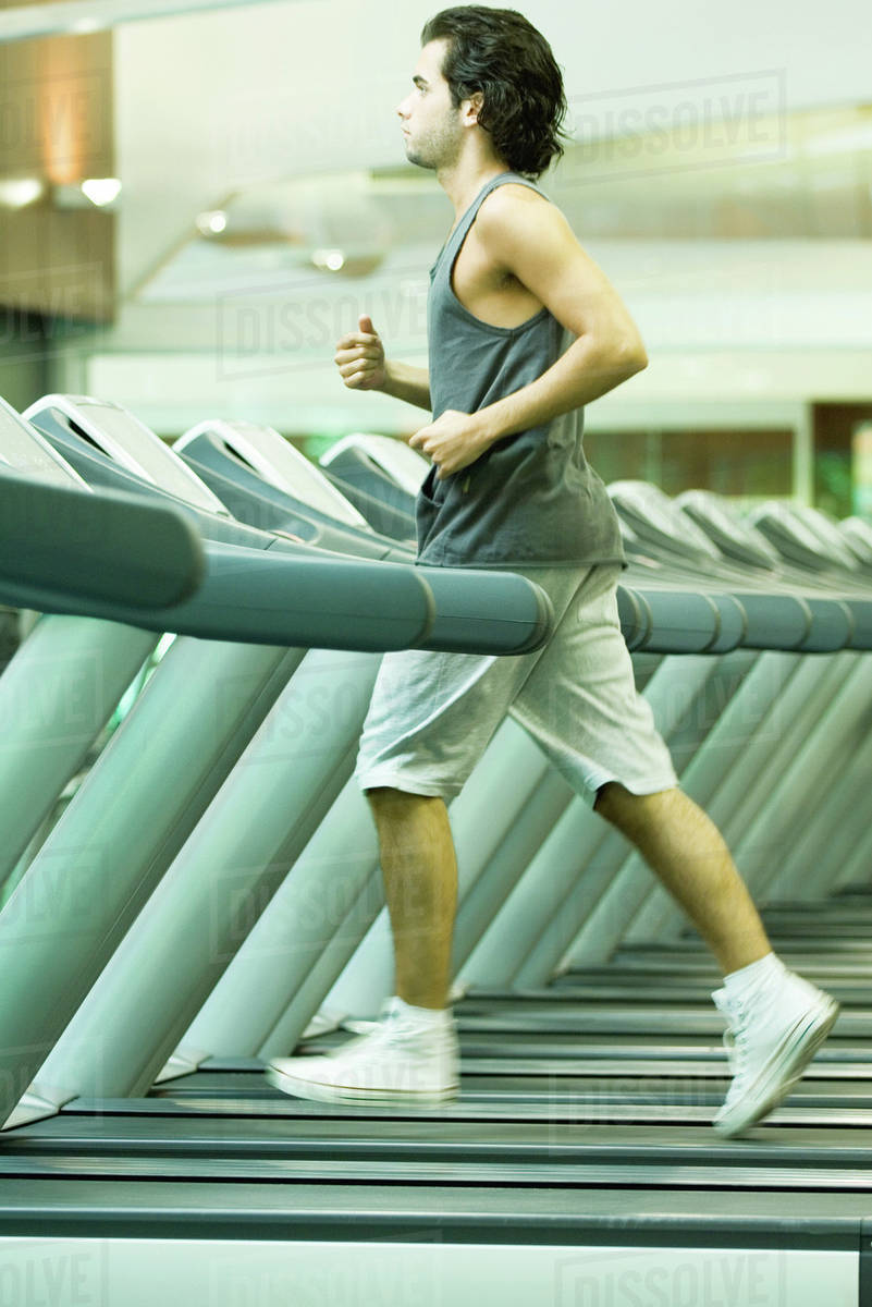 Man running on treadmill - Stock Photo - Dissolve