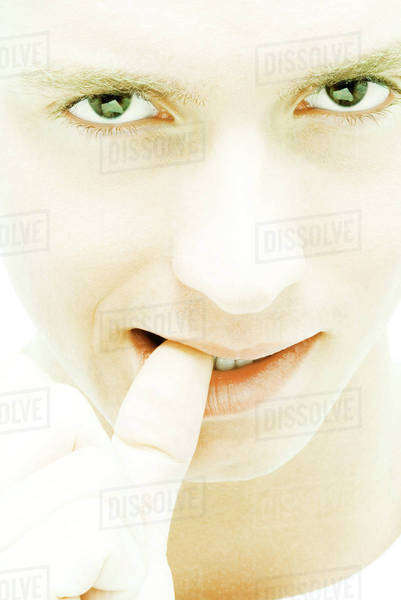 Young man biting thumb - Stock Photo - Dissolve