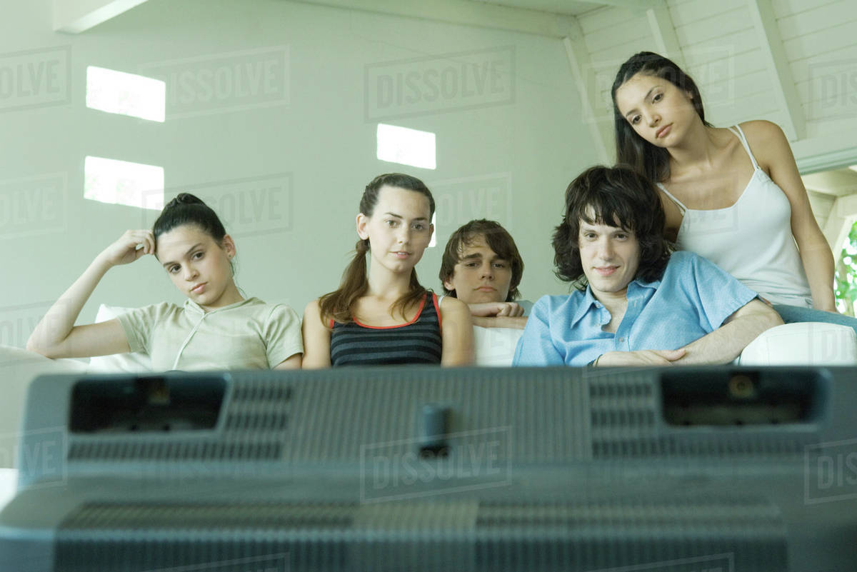 Group of young friends watching TV - Royalty-free Stock Photo | Dissolve