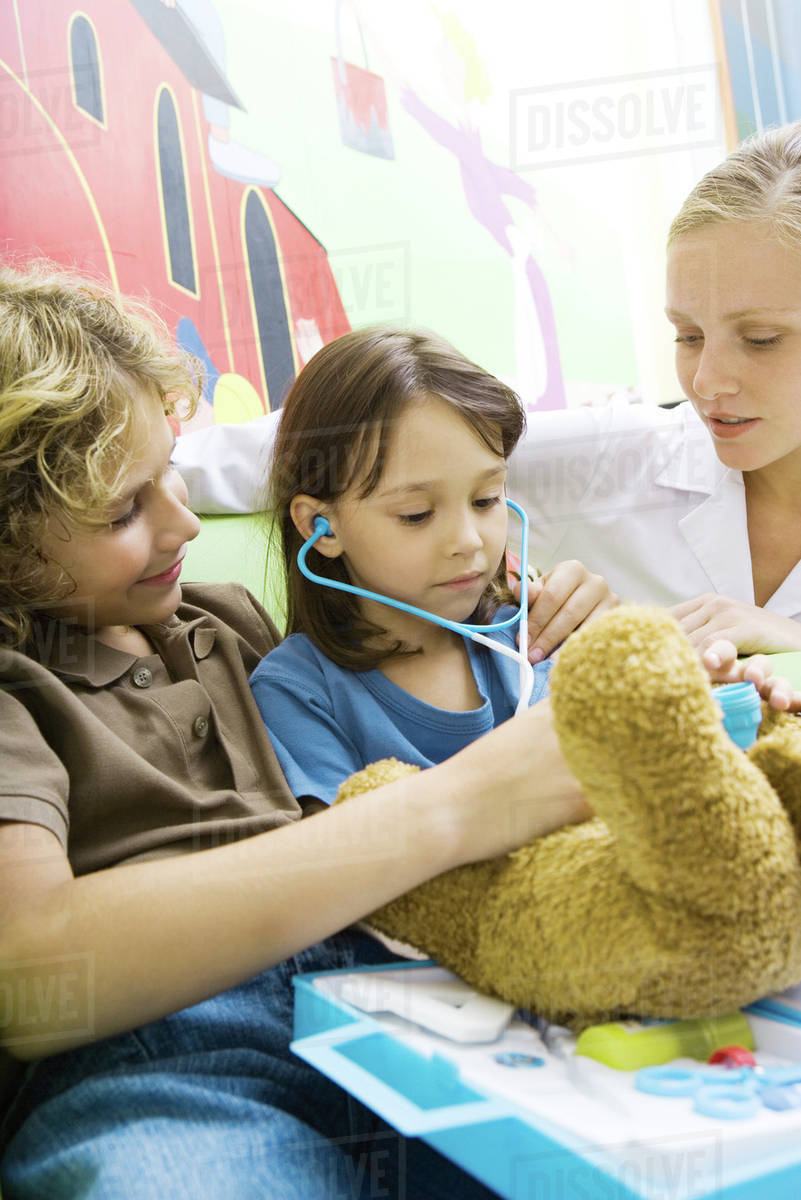 Boy and girl playing doctor with teddy bear - Royalty-free Stock Photo ...
