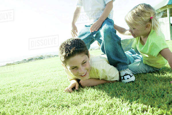 Children playing on grass - Royalty-free Stock Photo | Dissolve