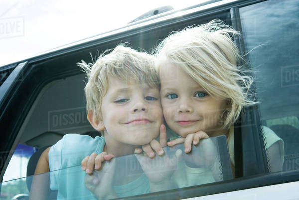 Children sticking heads out of car window - Stock Photo - Dissolve