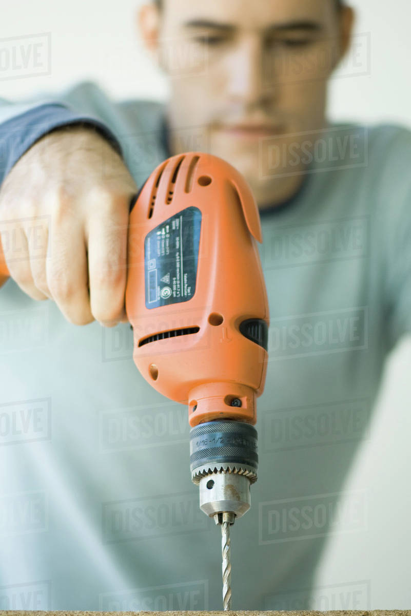Man using drill, focus on drill in foreground - Royalty-free Stock ...