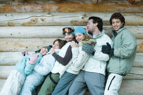 Group in winter clothes falling back onto each other, three quarter ...