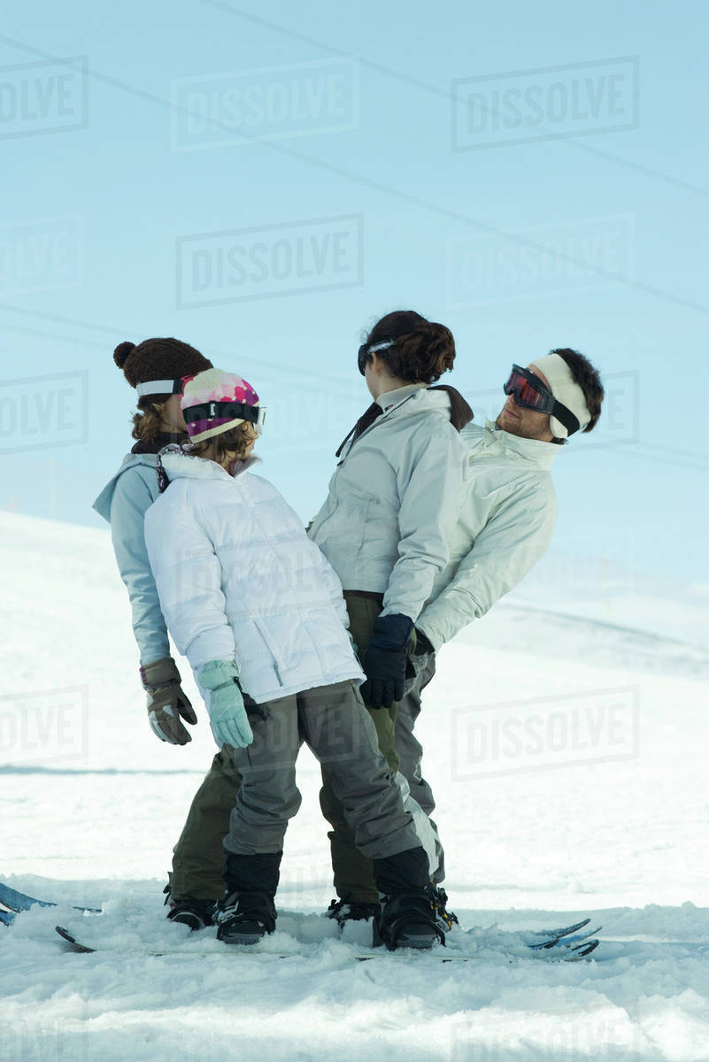 Group having fun in snow, full length - Stock Photo - Dissolve