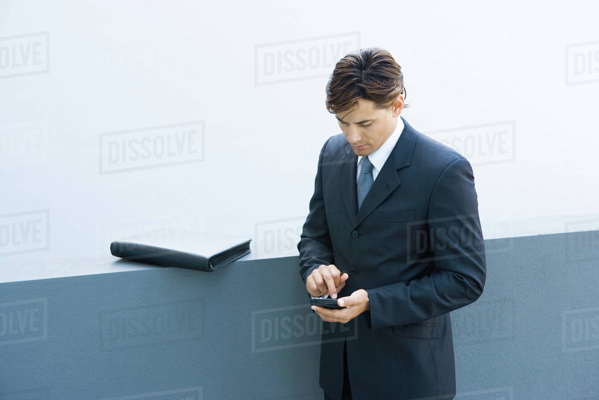 Young businessman using palmtop, looking down, high angle view ...