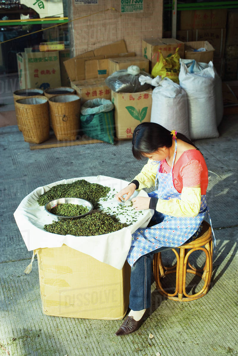 Woman sorting tea leaves in market - Royalty-free Stock Photo | Dissolve