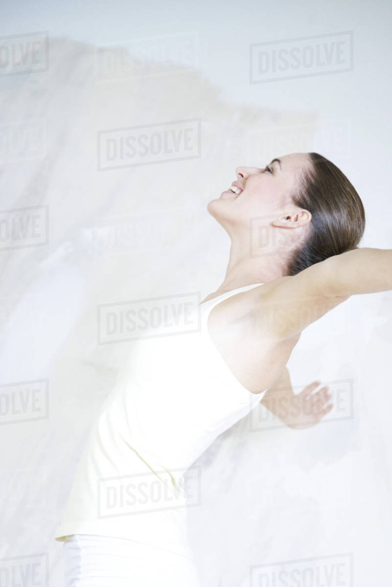 Woman leaning back, arms outstretched, smiling, side view - Royalty ...