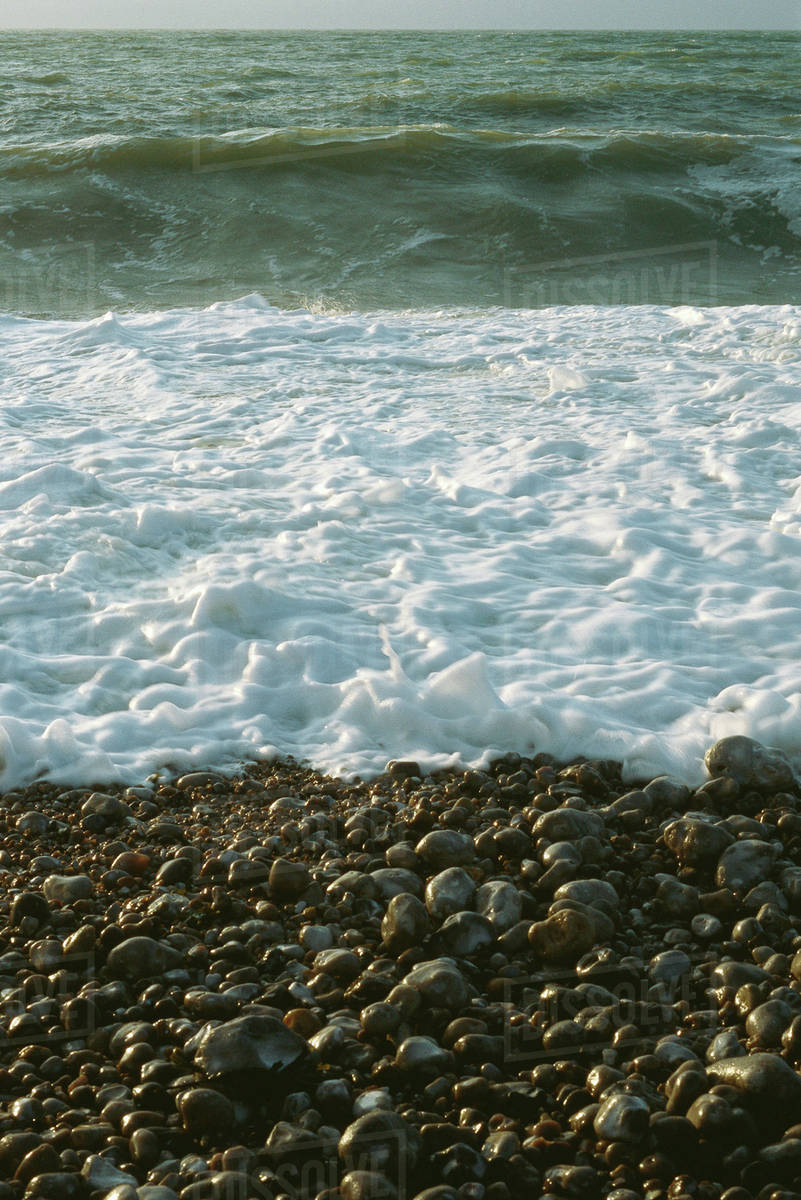 Surf washing over pebbles on beach - Royalty-free Stock Photo | Dissolve