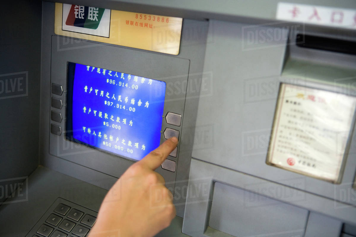 Person using ATM in China, cropped view - Stock Photo - Dissolve