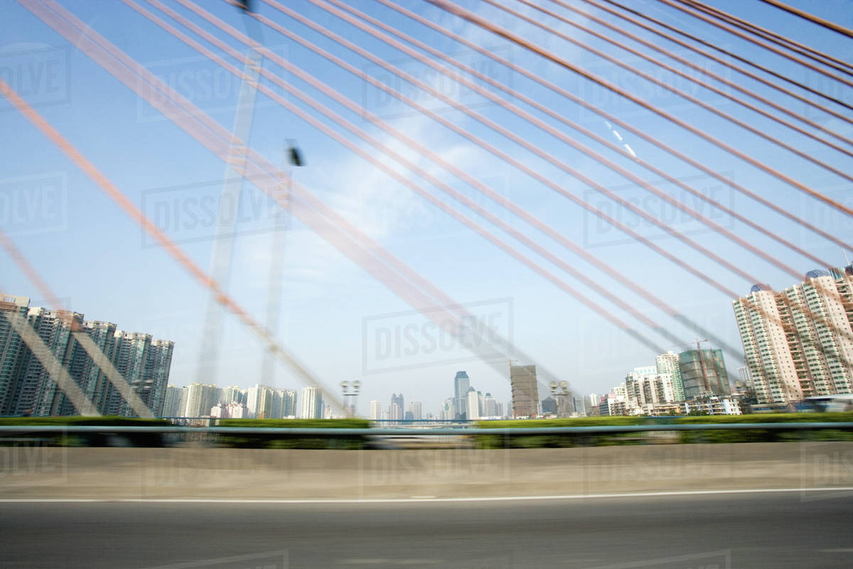 Suspension bridge, cropped view, cityscape in background - Stock Photo ...