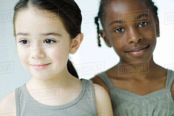 Two girls side by side, smiling, one looking at camera - Royalty-free ...