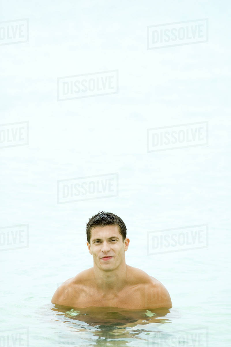 Muscular man chest deep in water, smiling at camera, front view - Stock ...