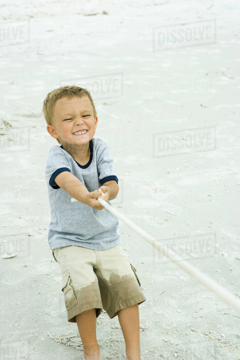 Little boy pulling on rope, making face, on beach - Royalty-free Stock ...