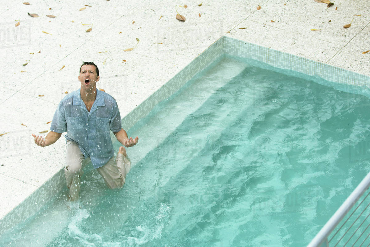 Man splashing in pool, fully clothed, shouting and gesticulating, high ...