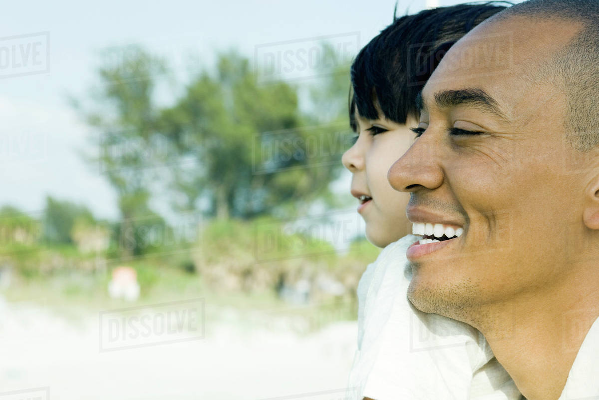 Father and son looking away together, smiling, side view - Stock Photo ...