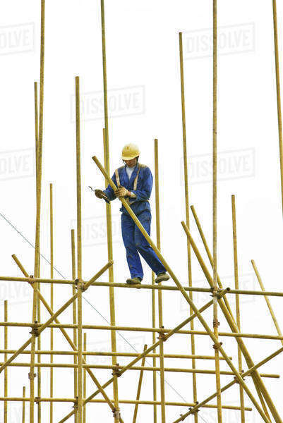 Man in hard hat assembling scaffolding - Royalty-free Stock Photo ...