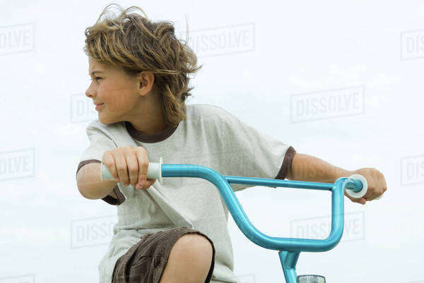 Boy riding bicycle, looking over shoulder, close-up - Royalty-free ...