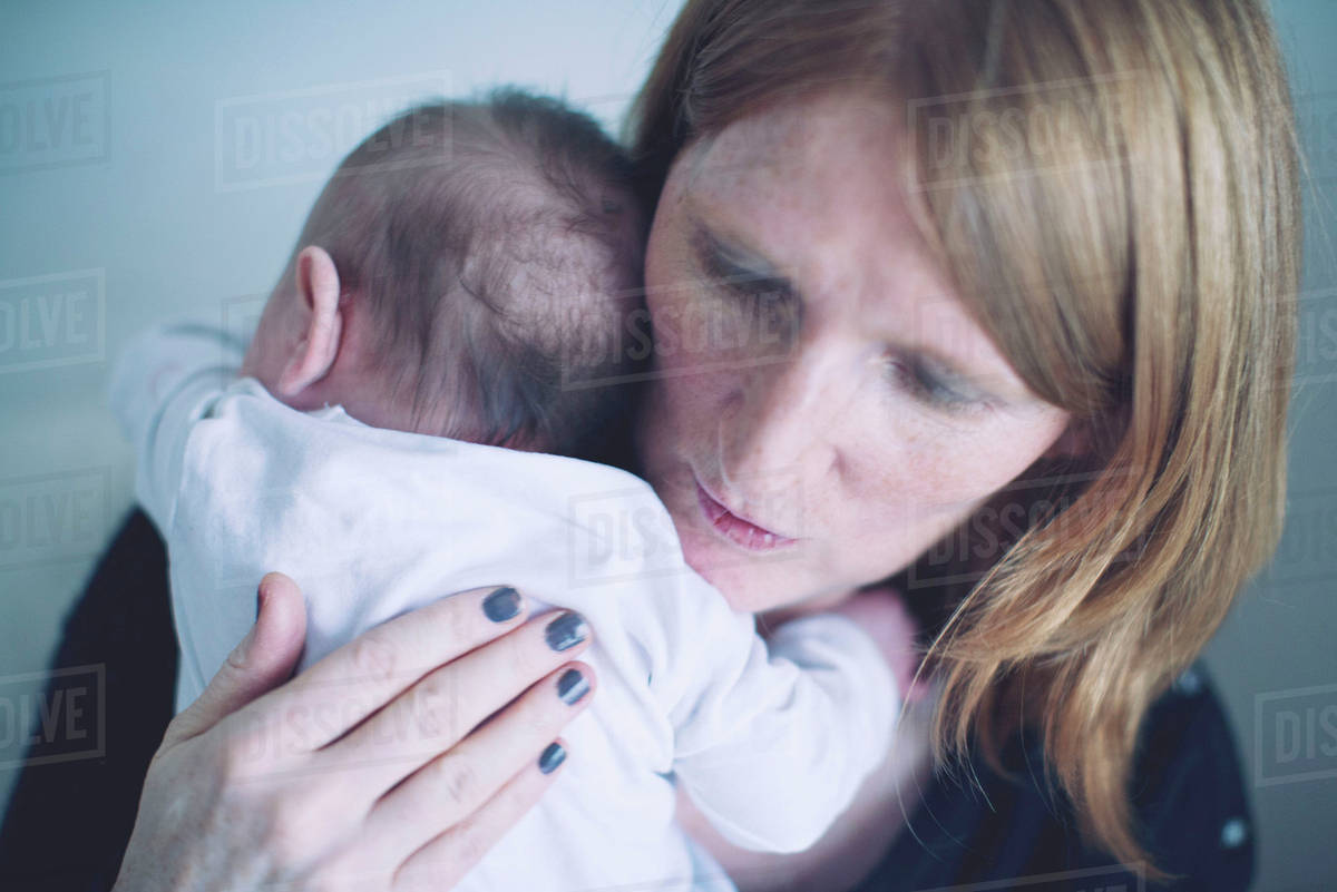 Mother comforting newborn baby - Stock Photo - Dissolve