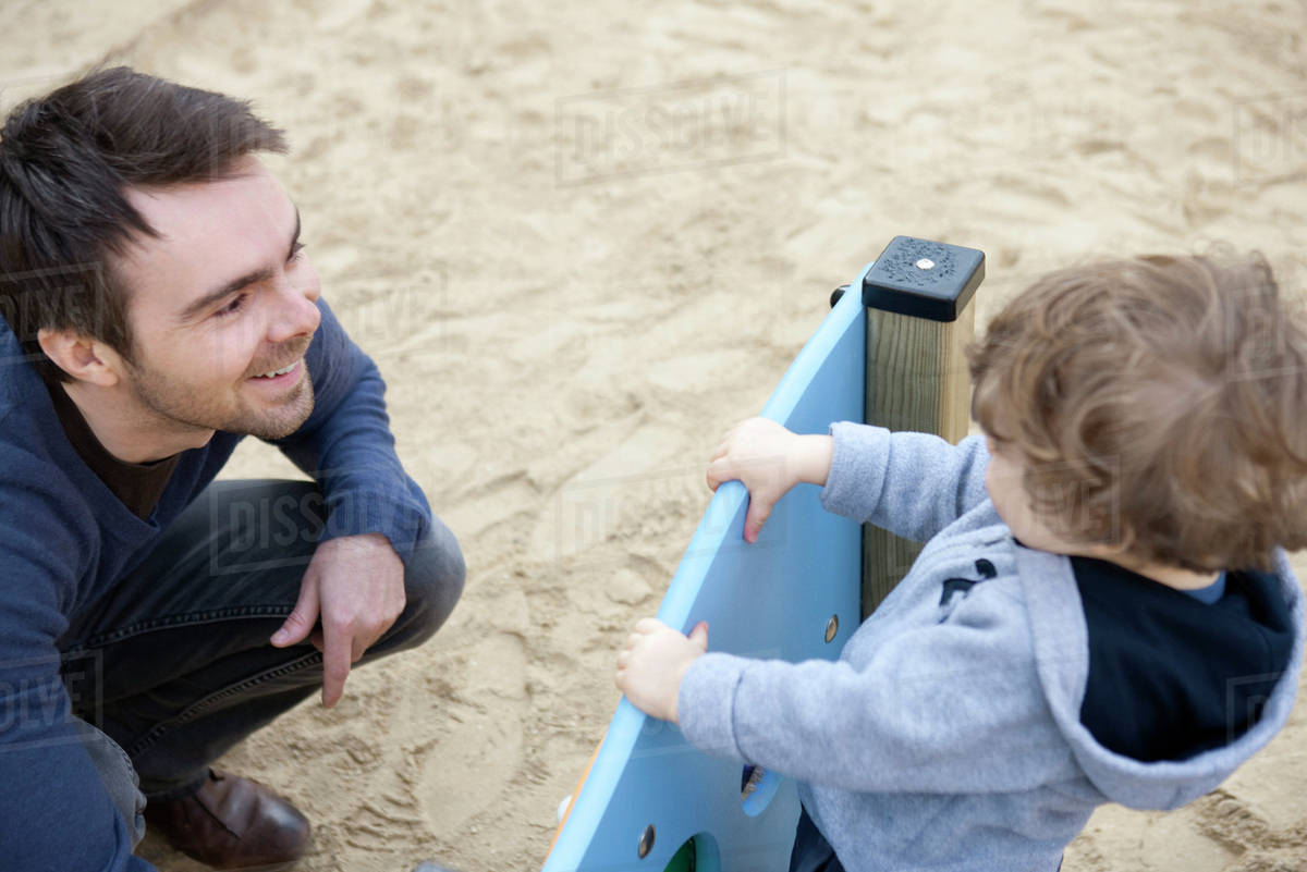 Father and toddler son playing on playground - Stock Photo - Dissolve