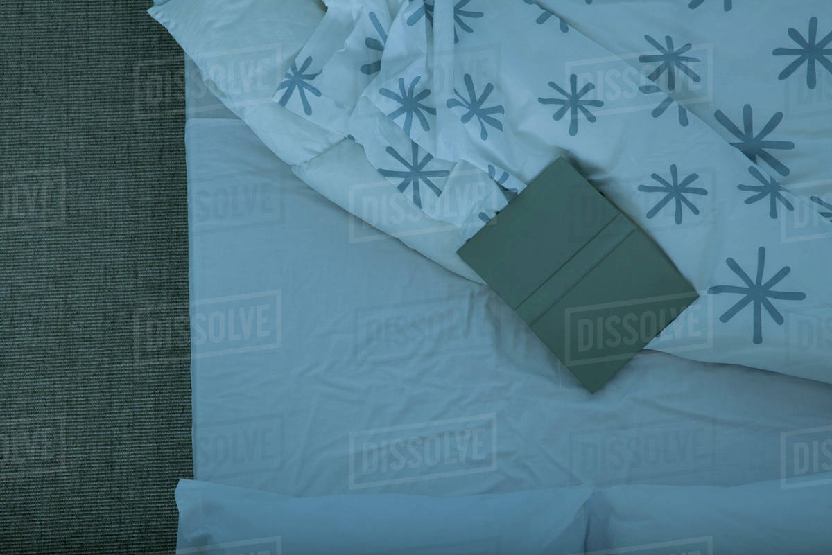 Open book lying face down on empty bed - Royalty-free Stock Photo ...